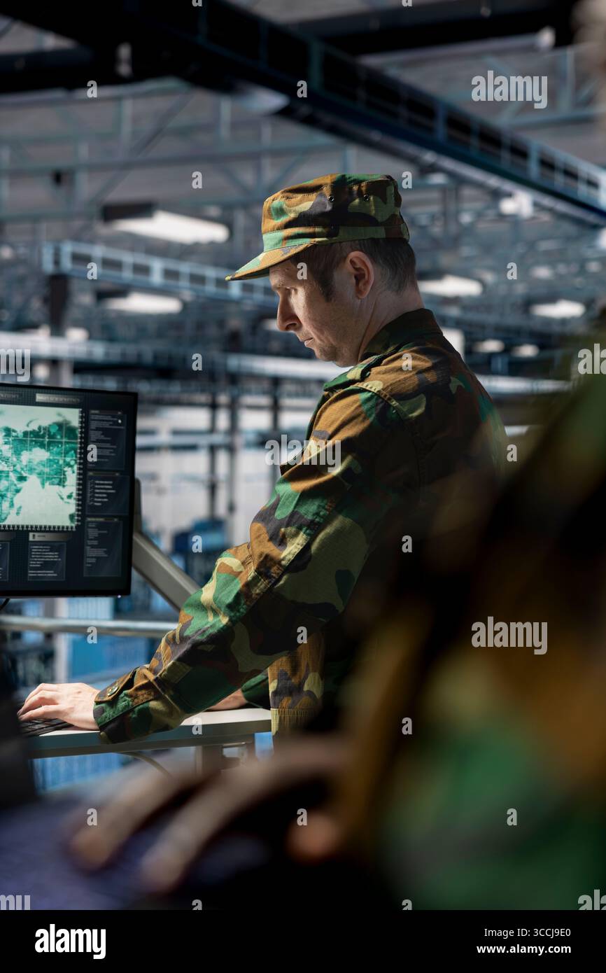 Soldier in server hub checking reports at data operations workstation ...