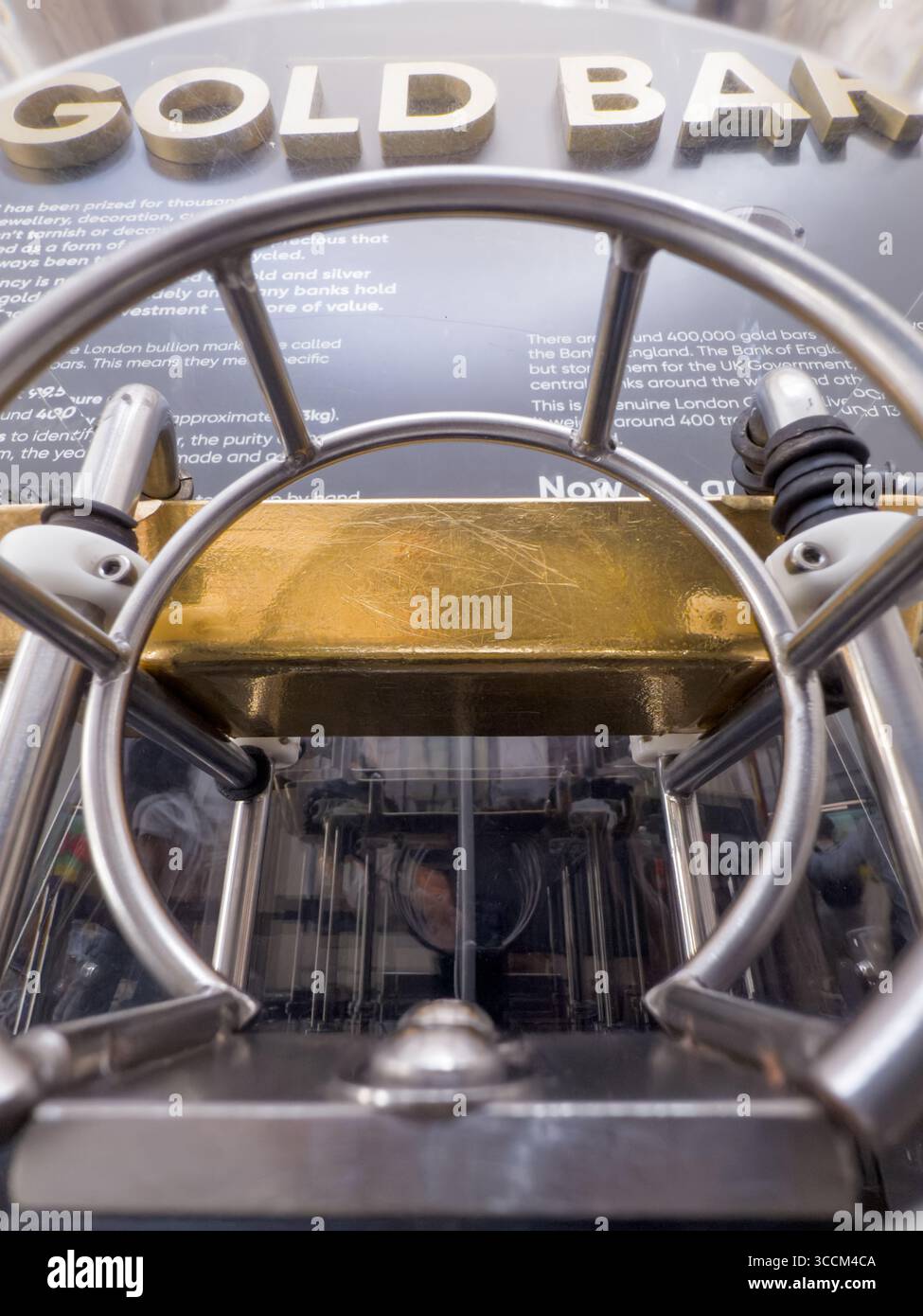 A standard gold bar is securely held and showcased as part of an ...