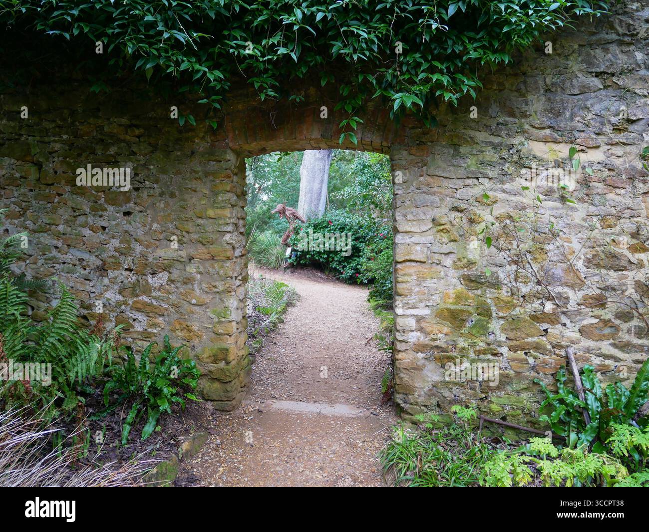 Stone wall and archway with wicker wolf in background at Abbotsbury ...