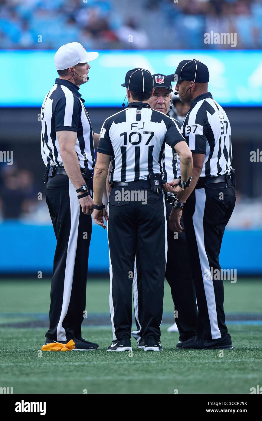 Referee Clay Martin (left) huddles with field judge Dave Hawkshaw (107 ...