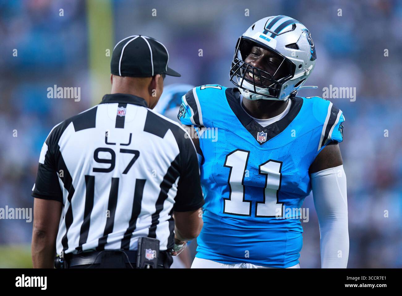 Carolina Panthers linebacker Nic Scourton (11) smiles while talking to line judge Brian Perry ...