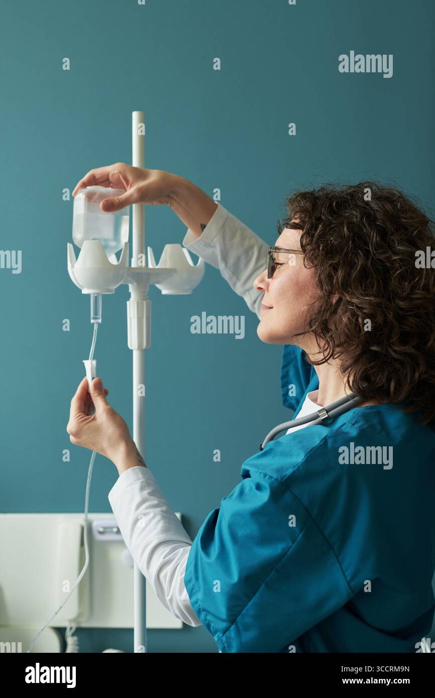 Doctor adjusting iv tubing patient hi-res stock photography and images ...
