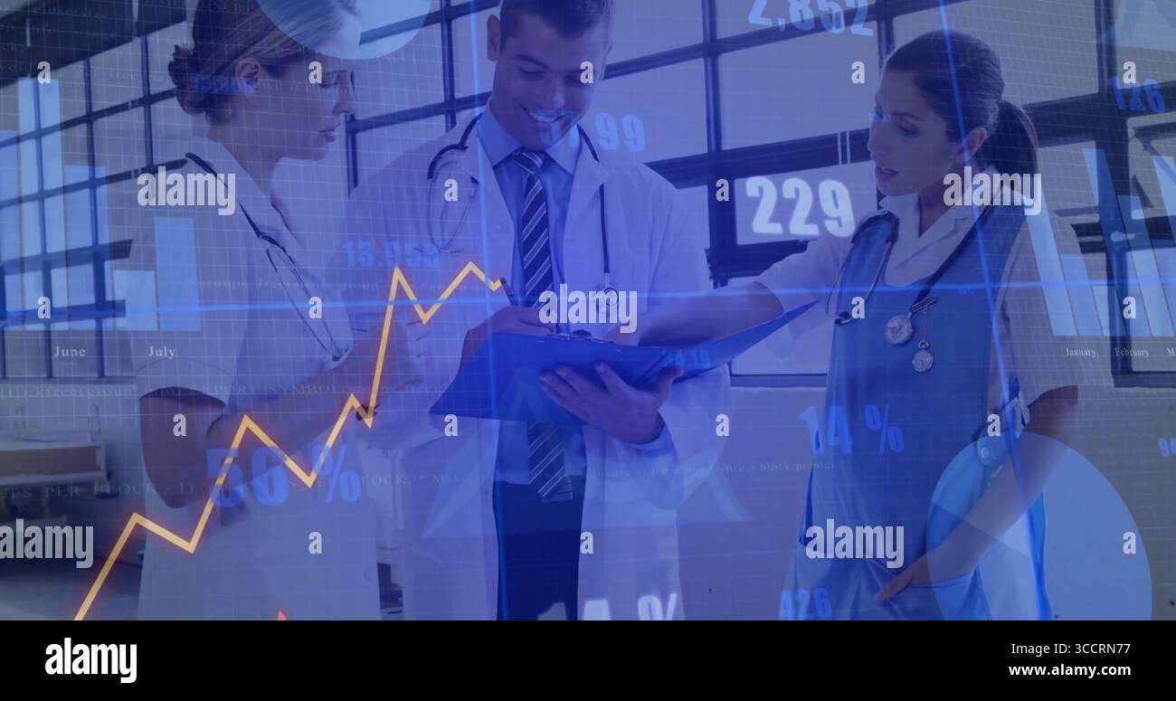 Reviewing medical team examining patient data in hospital ward, with ...