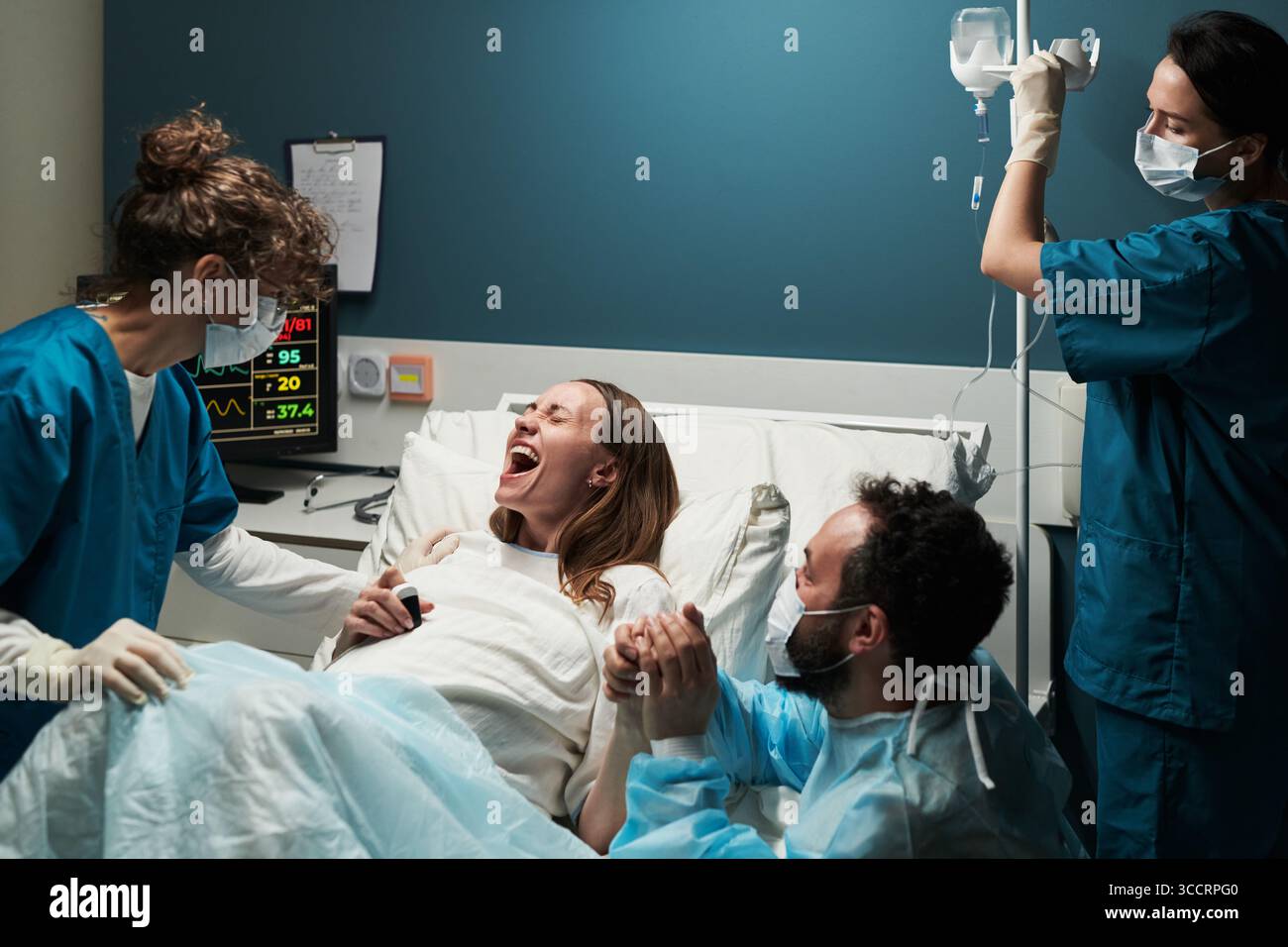 Caucasian young adult woman lying in hospital bed giving birth assisted ...
