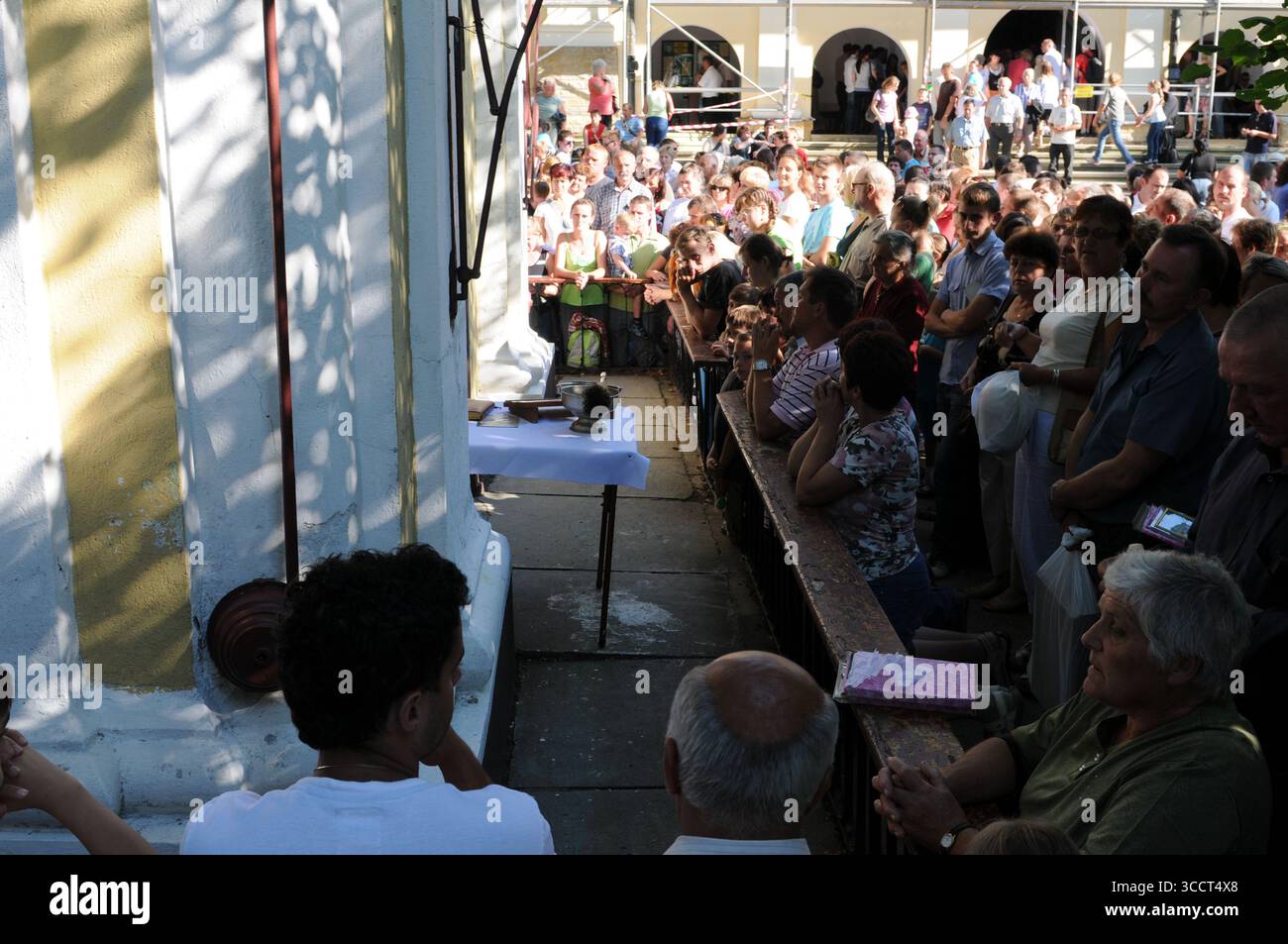 People attending an outdoor Catholic mass, priest giving communion ...
