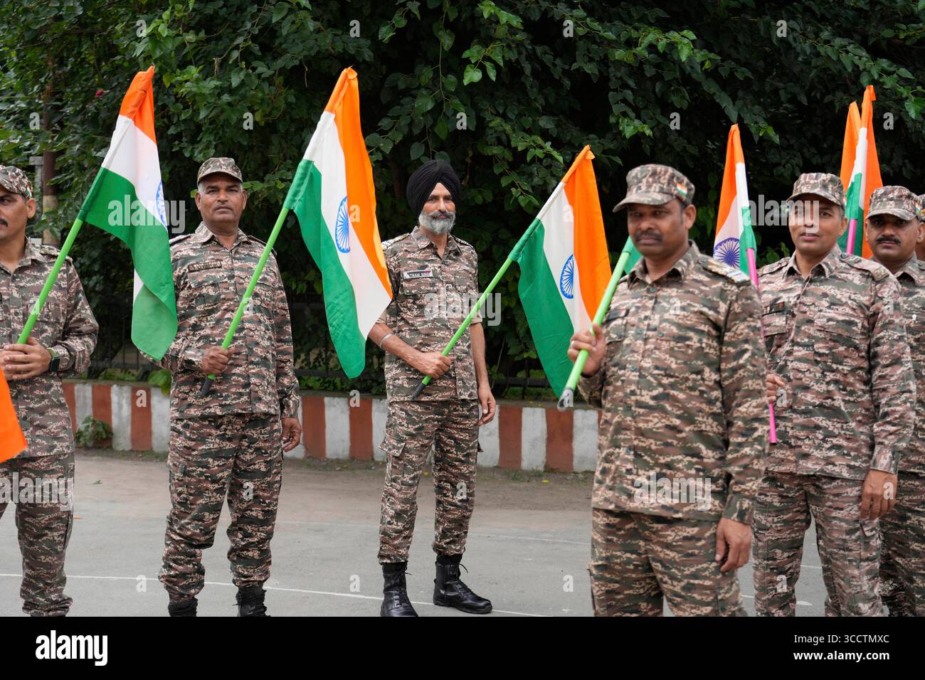 Indian paramilitary soldiers march holding the Indian flag as part of a ...