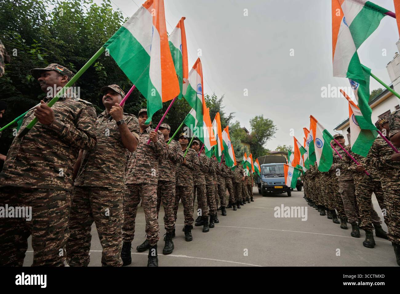 Indian paramilitary soldiers march holding the Indian flag as part of a ...