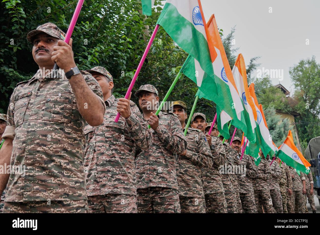 Indian paramilitary soldiers march holding the Indian flag as part of a ...