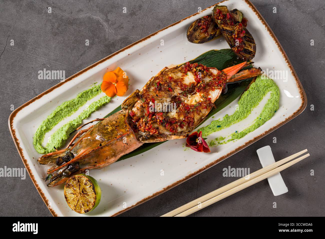 Grilled tiger shrimp served with green sauce, grilled lime, and herbs ...