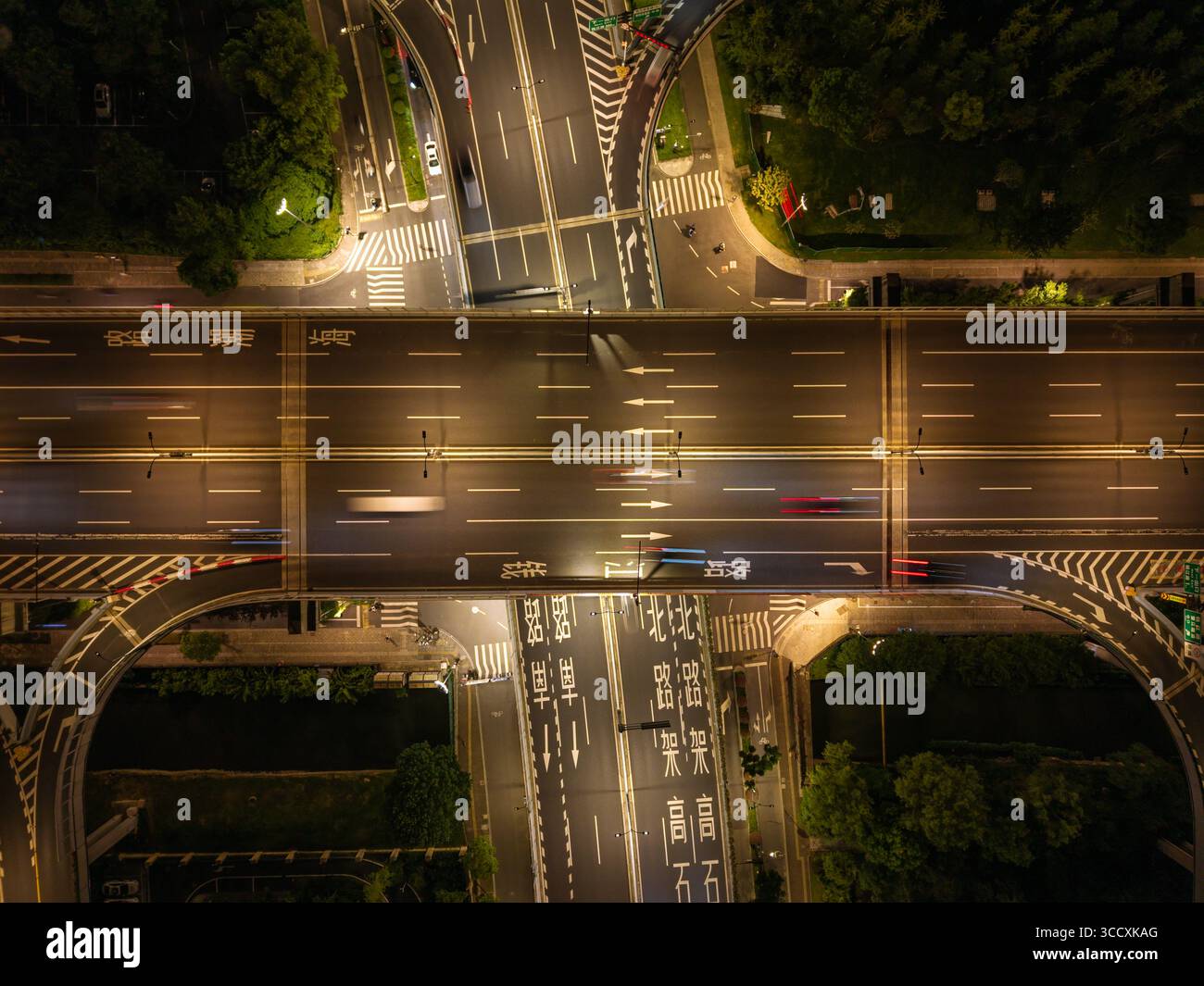 Aerial view of cars move along a brightly illuminated highway ...