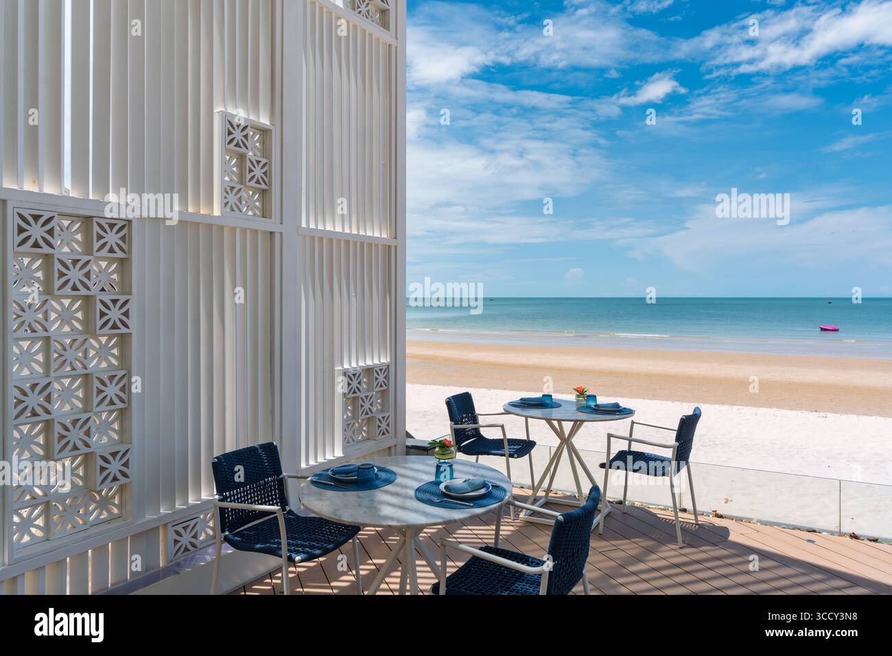Stylish beachfront restaurant terrace with modern white block wall ...