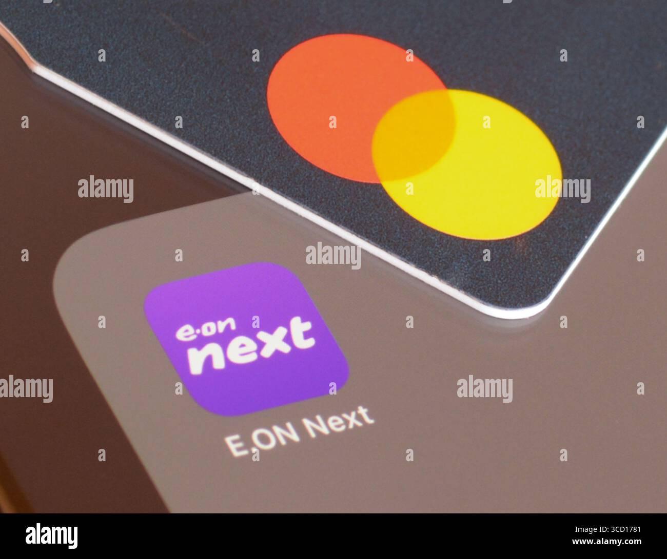 E-ON Next utilitiy app on smartphone screen with Mastercard to pay bill ...