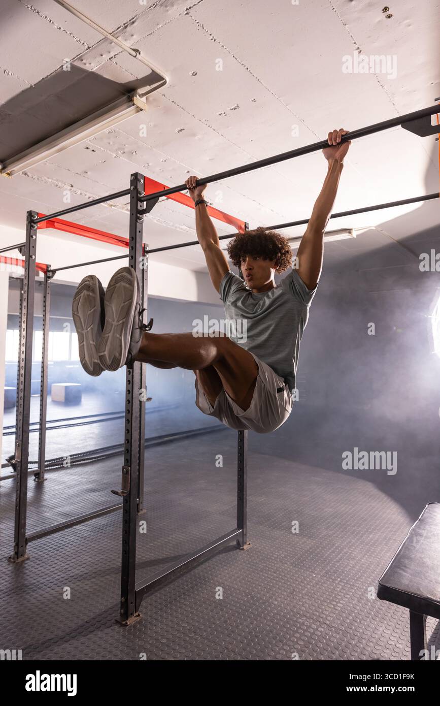 Pull-up rig hanging under ceiling pipes and lights in gym studio, bench ...
