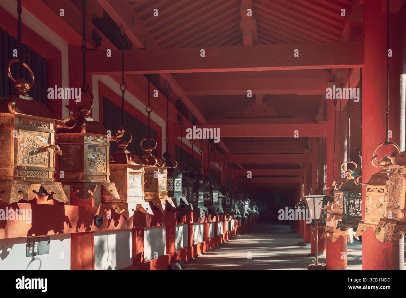 Traditional bronze lantern corridor with red pillars at Kasuga-taisha ...