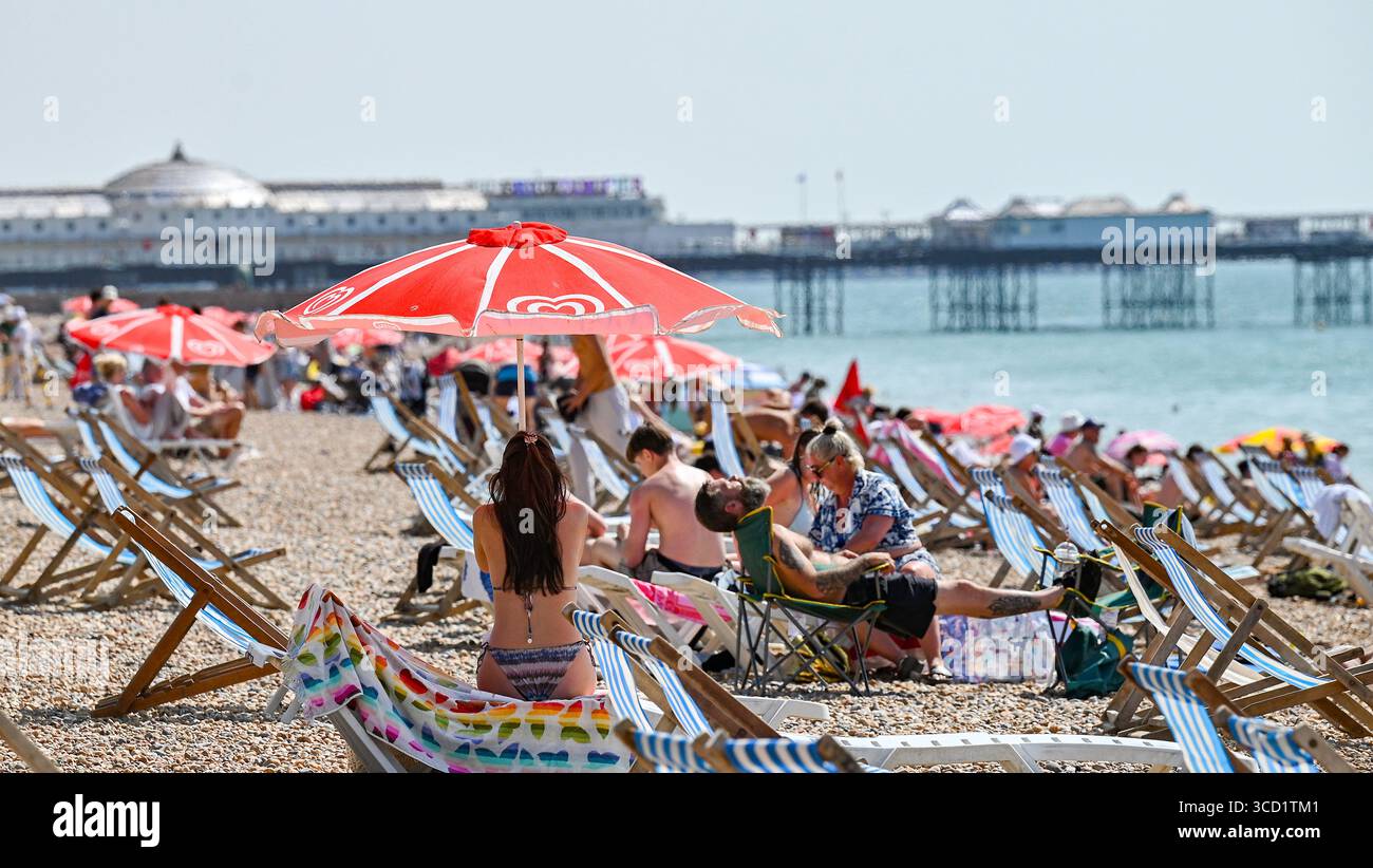 Brighton UK 12th August 2025 - Sunseekers enjoy the hot sunshine on ...