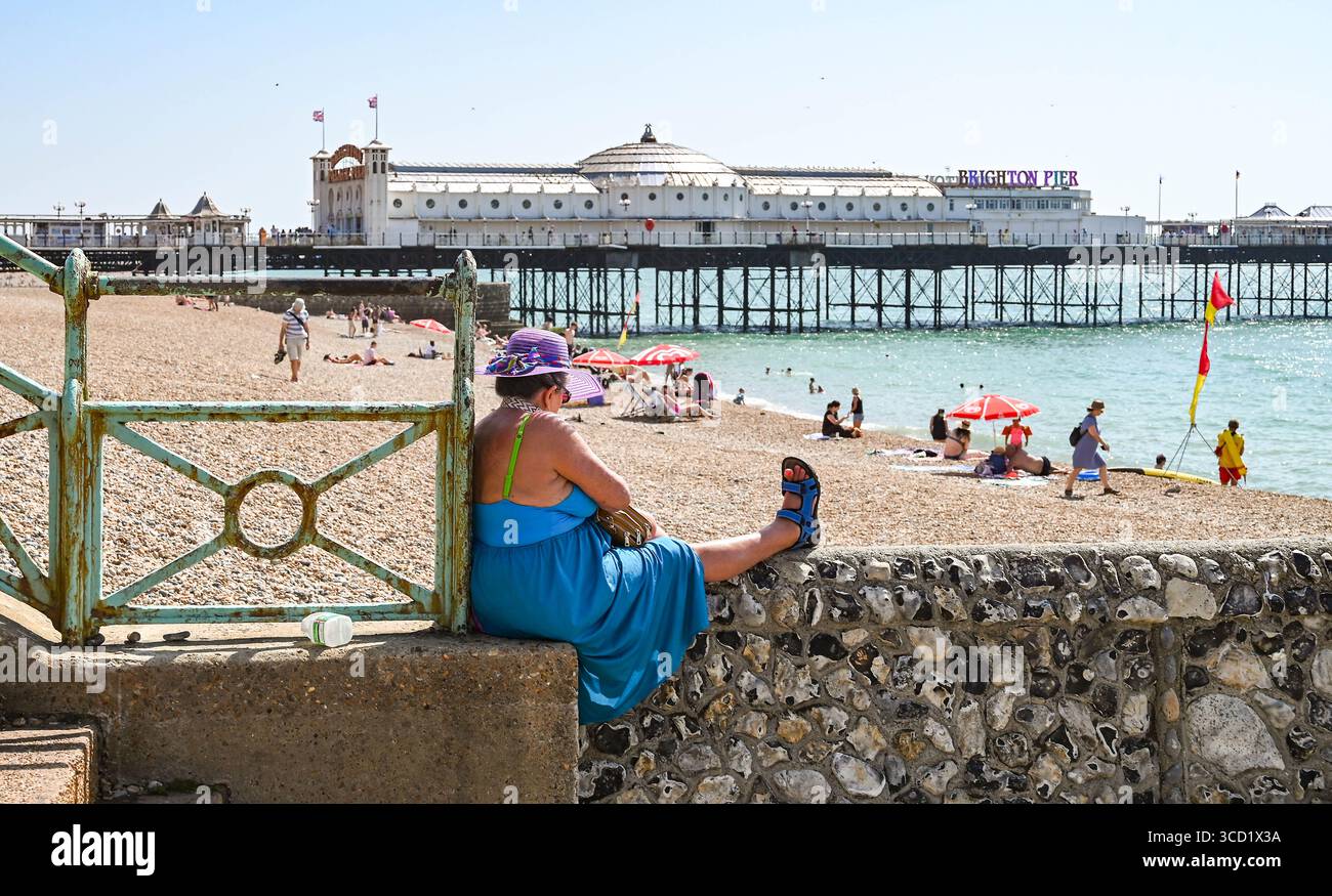 Brighton UK 12th August 2025 - Sunseekers enjoy the hot sunshine on ...