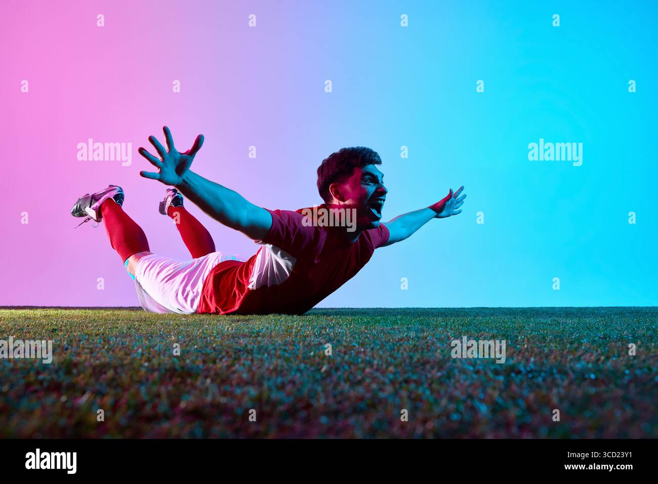 Soccer player sliding on grass celebrating victory Stock Photo - Alamy