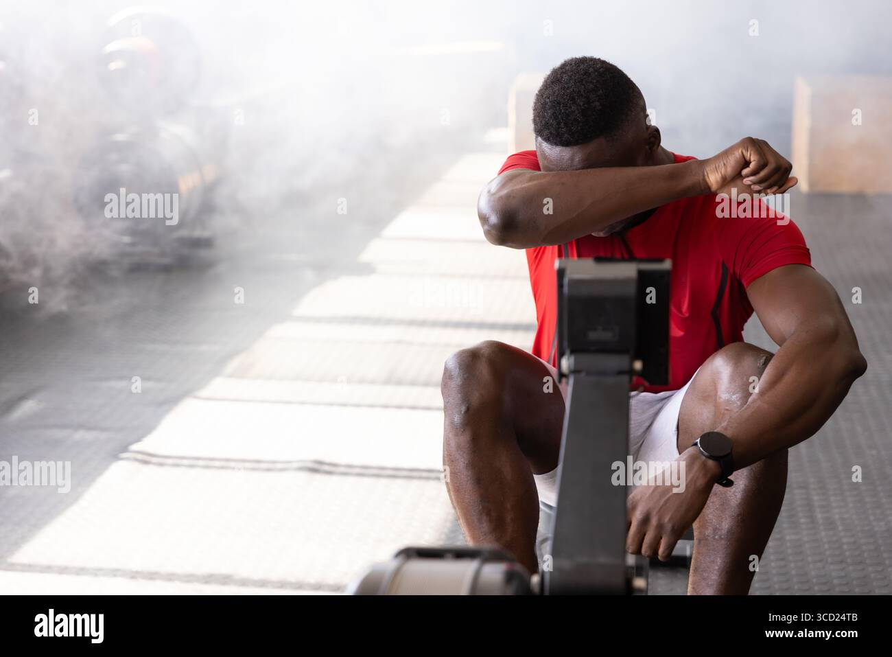 African American man wiping sweat from forehead after rowing on rowing ...