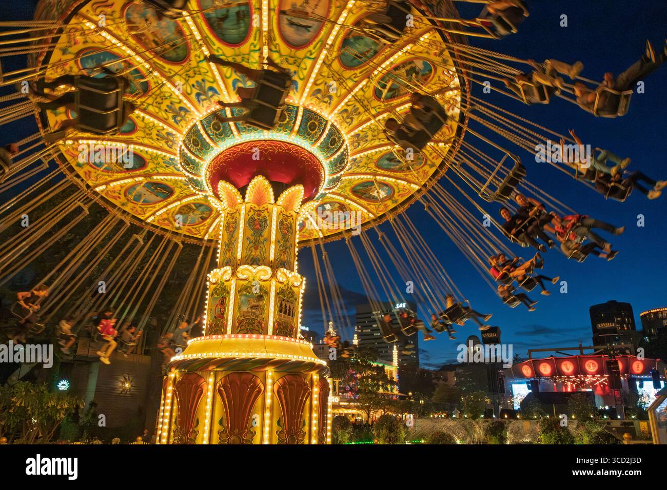 Illuminated carousel at Tivoli amusement park in Copenhagen at night ...