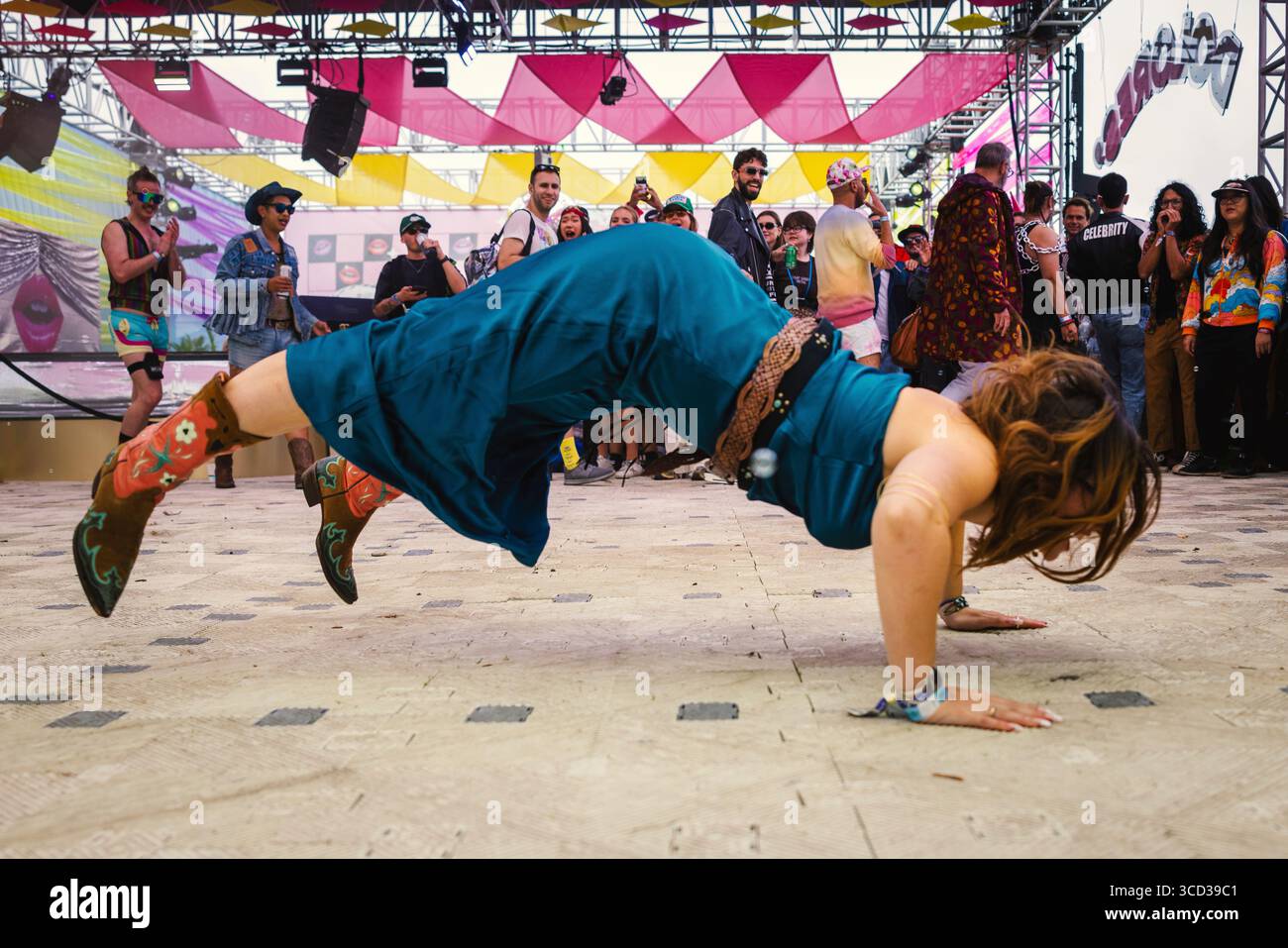 A woman does the worm while dancing in a circle at the Dolores tent ...