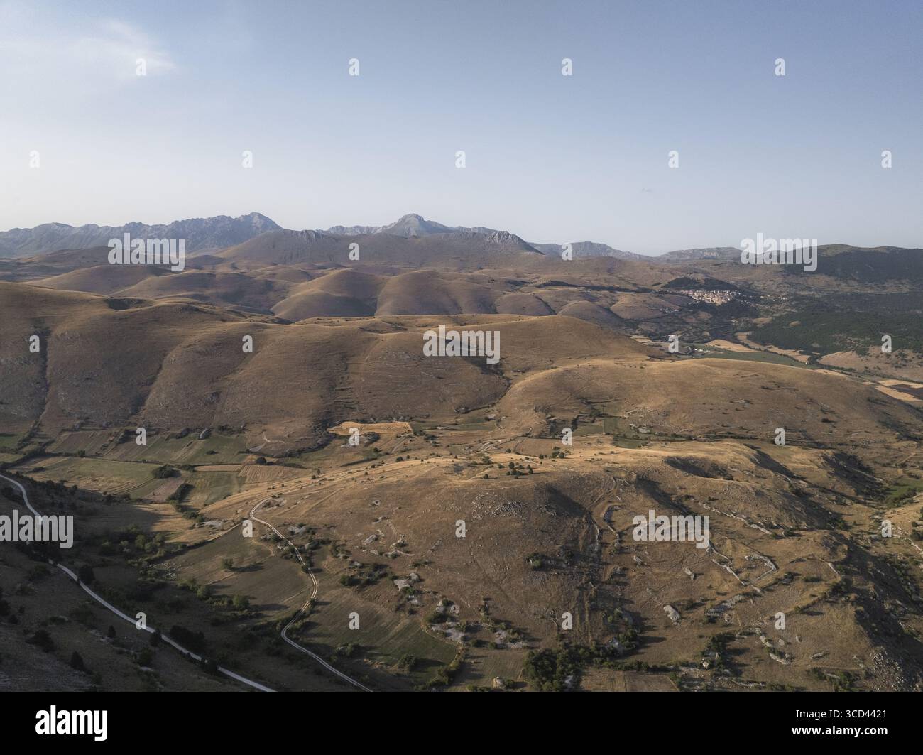 Aerial view of sun-kissed rolling hills cascade towards the distant ...