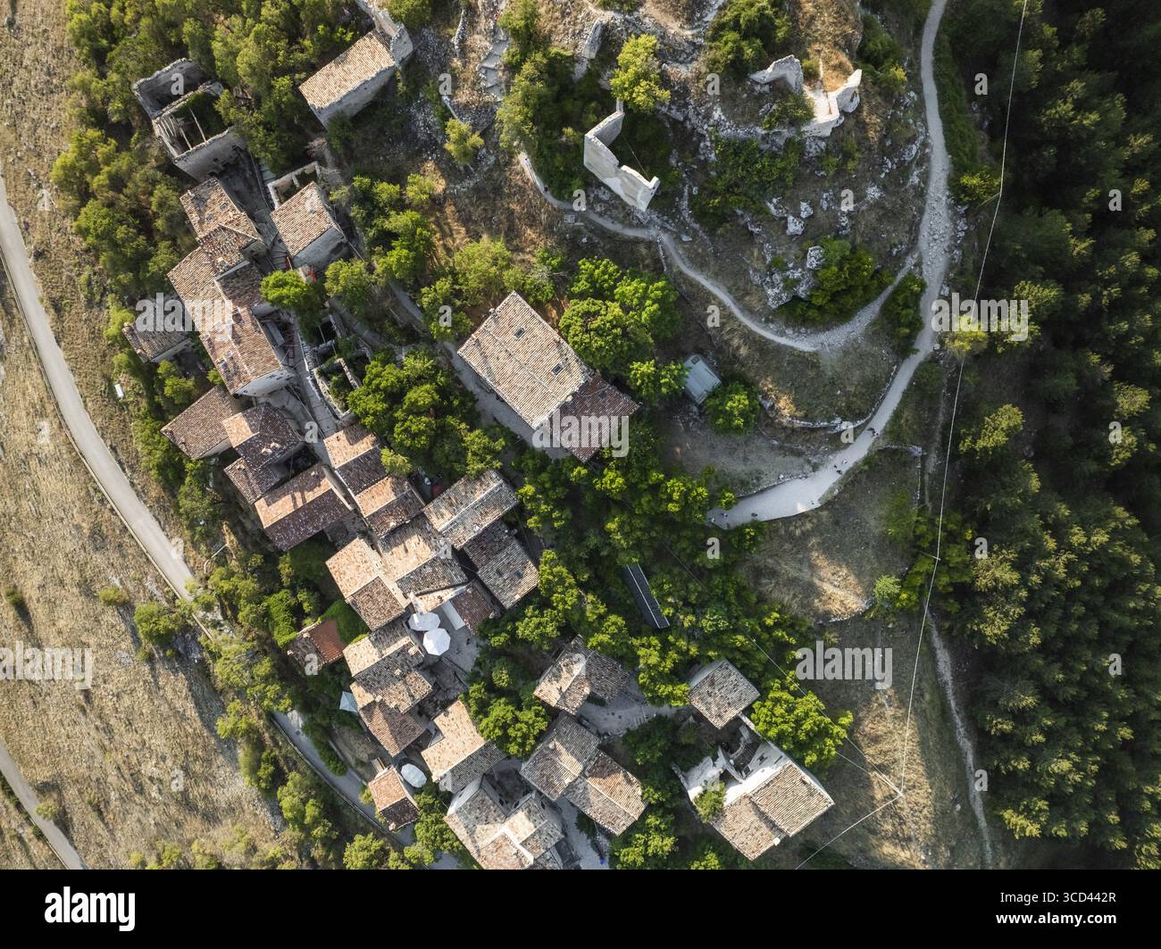 Aerial view of ancient stone buildings clinging to a hilltop, kissed by ...