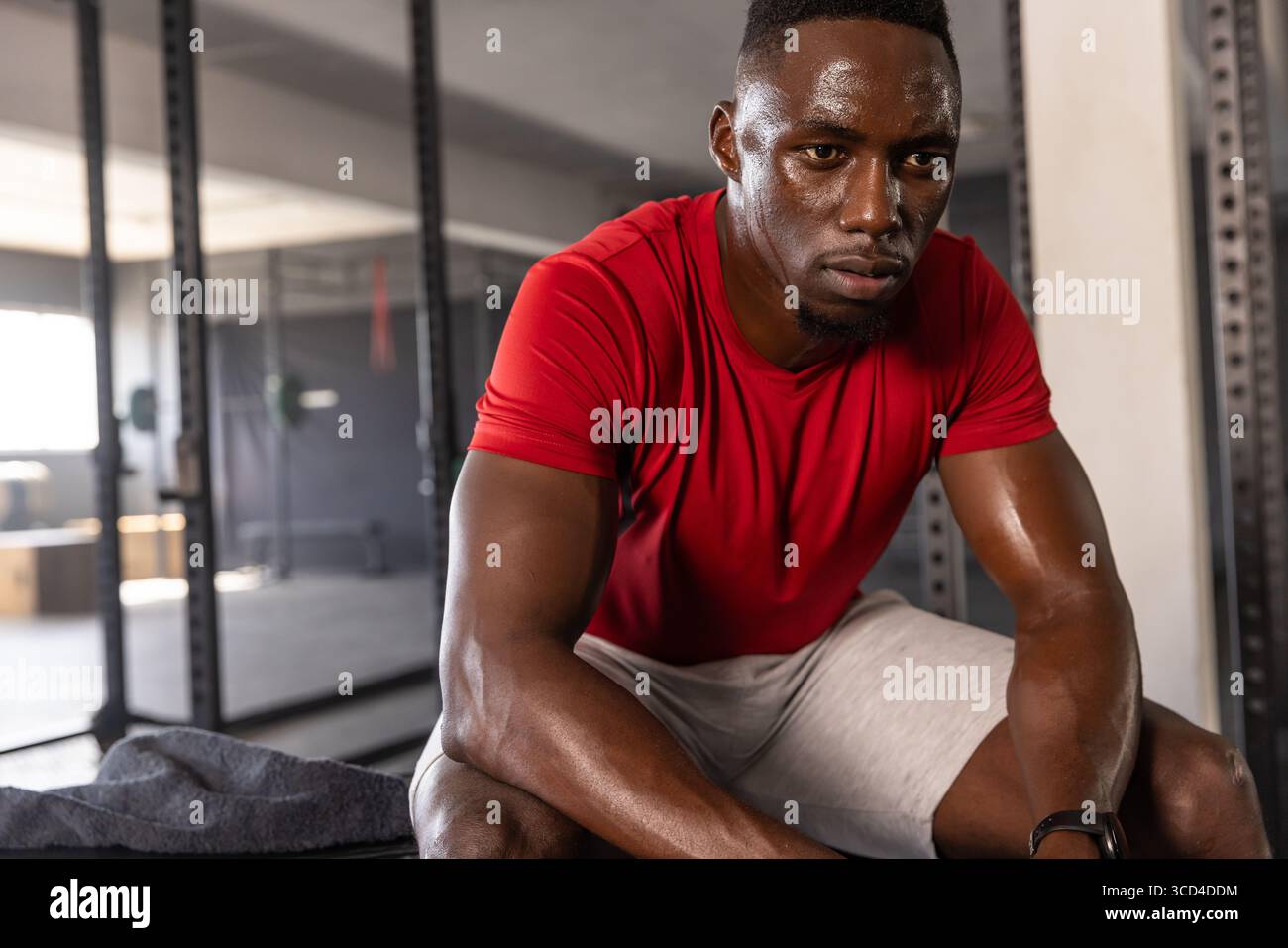 African American man sitting on bench leaning forward, breathing hard ...