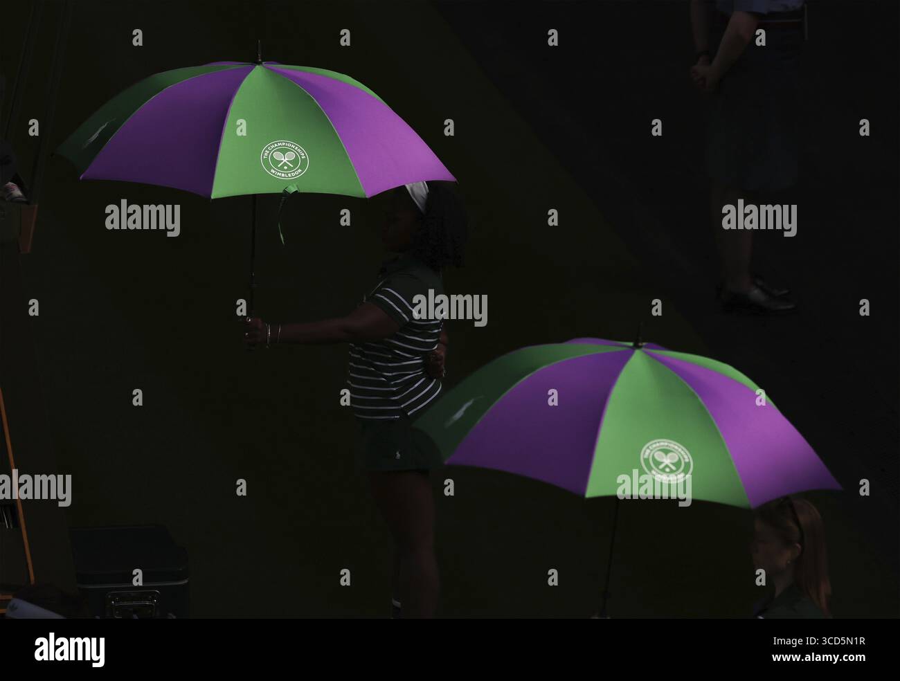 Ballboys holding 2 umbrellas to shade players at the 2025 Wimbledon ...