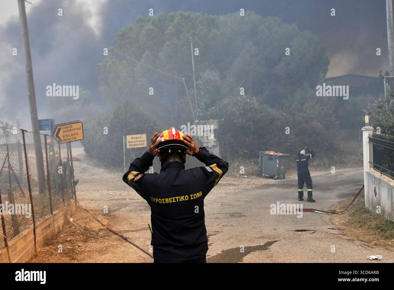 Black smoke covers the sky during a wildfire in the village of ...