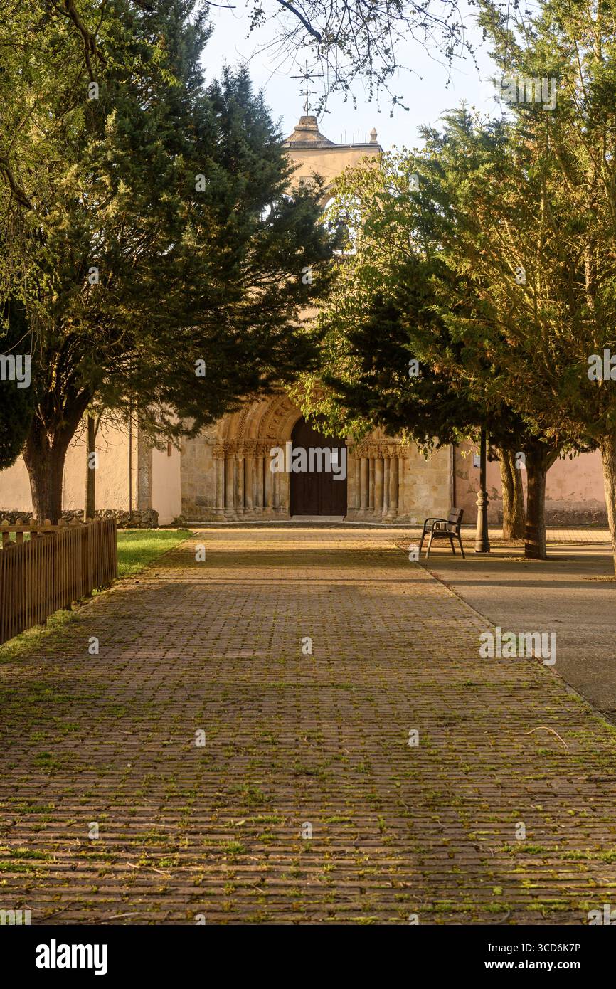 Romanesque abbey with stone bell gable and arched doorway in a peaceful ...
