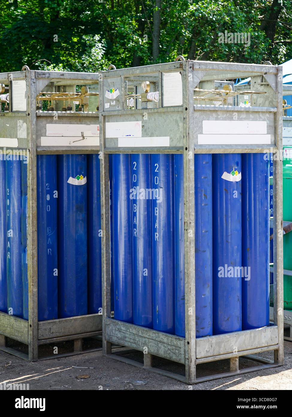 Blue industrial high-pressure oxygen gas cylinders securely stored in ...