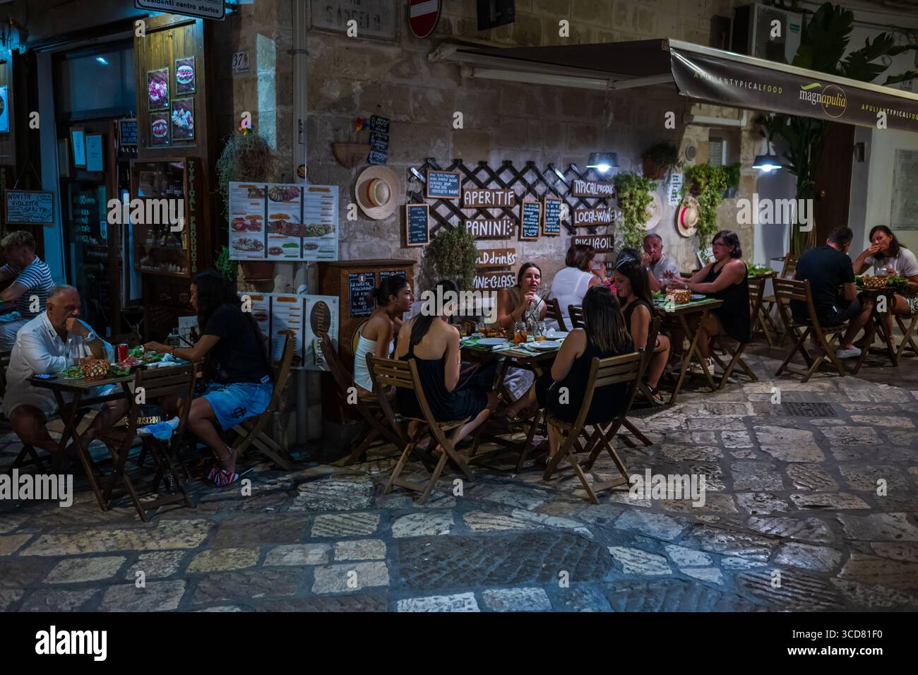 Busy restaurant terraces at night in Monopoli, Italy Stock Photo - Alamy