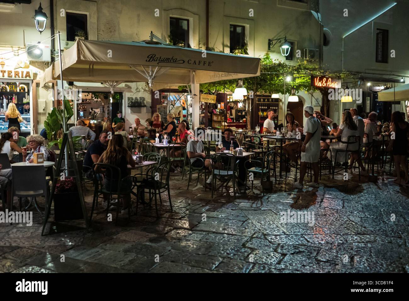 Busy restaurant terraces at night in Monopoli, Italy Stock Photo - Alamy