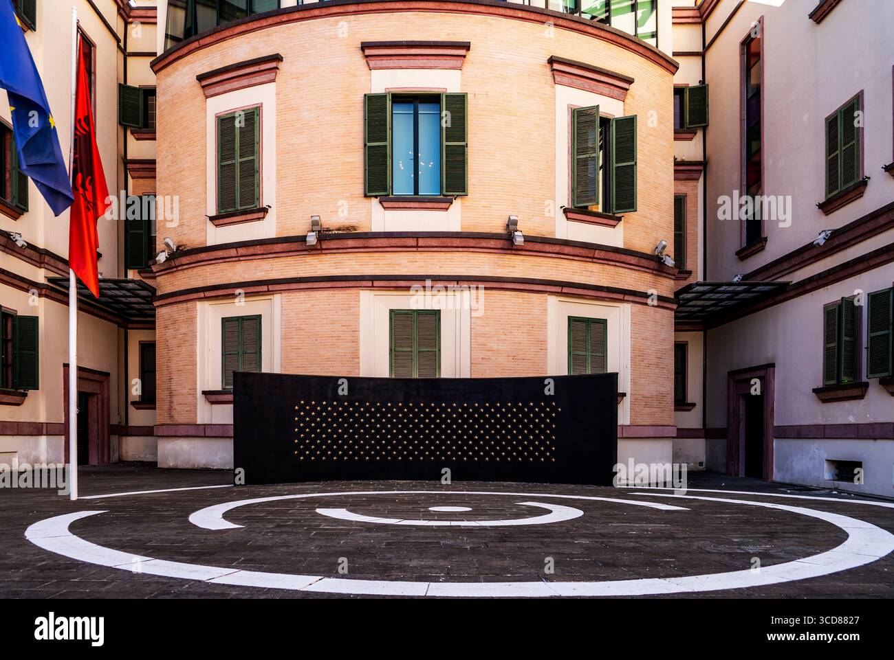 A circular courtyard with a modern art installation and flags Stock ...
