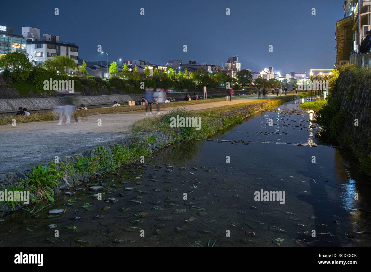 Shallow canal flowing on the West side of the Kamogawa River at night ...