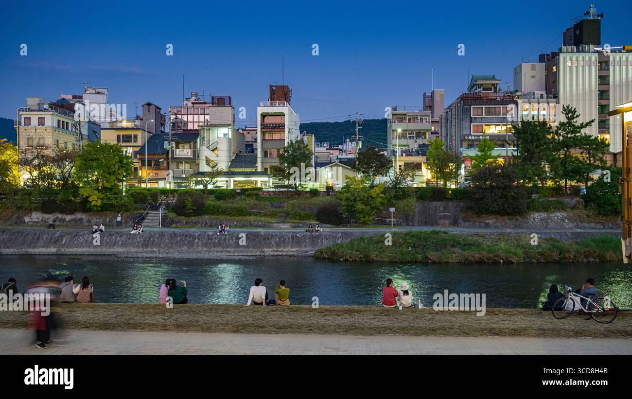 People sitting on the banks of the Kamogawa River, Pontocho entrainment ...