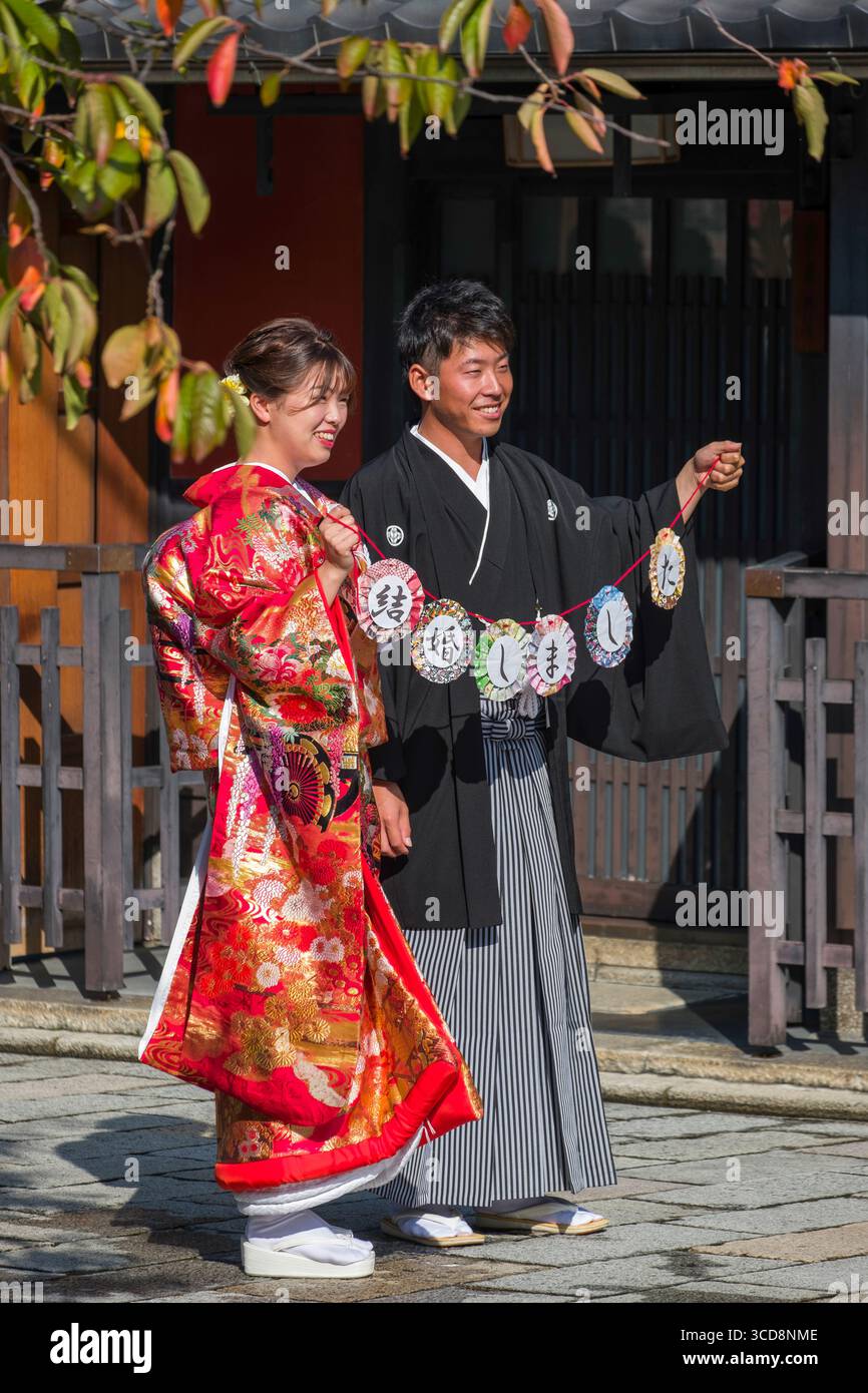 Woman and man dressed in traditional Japanese attire posing for a ...