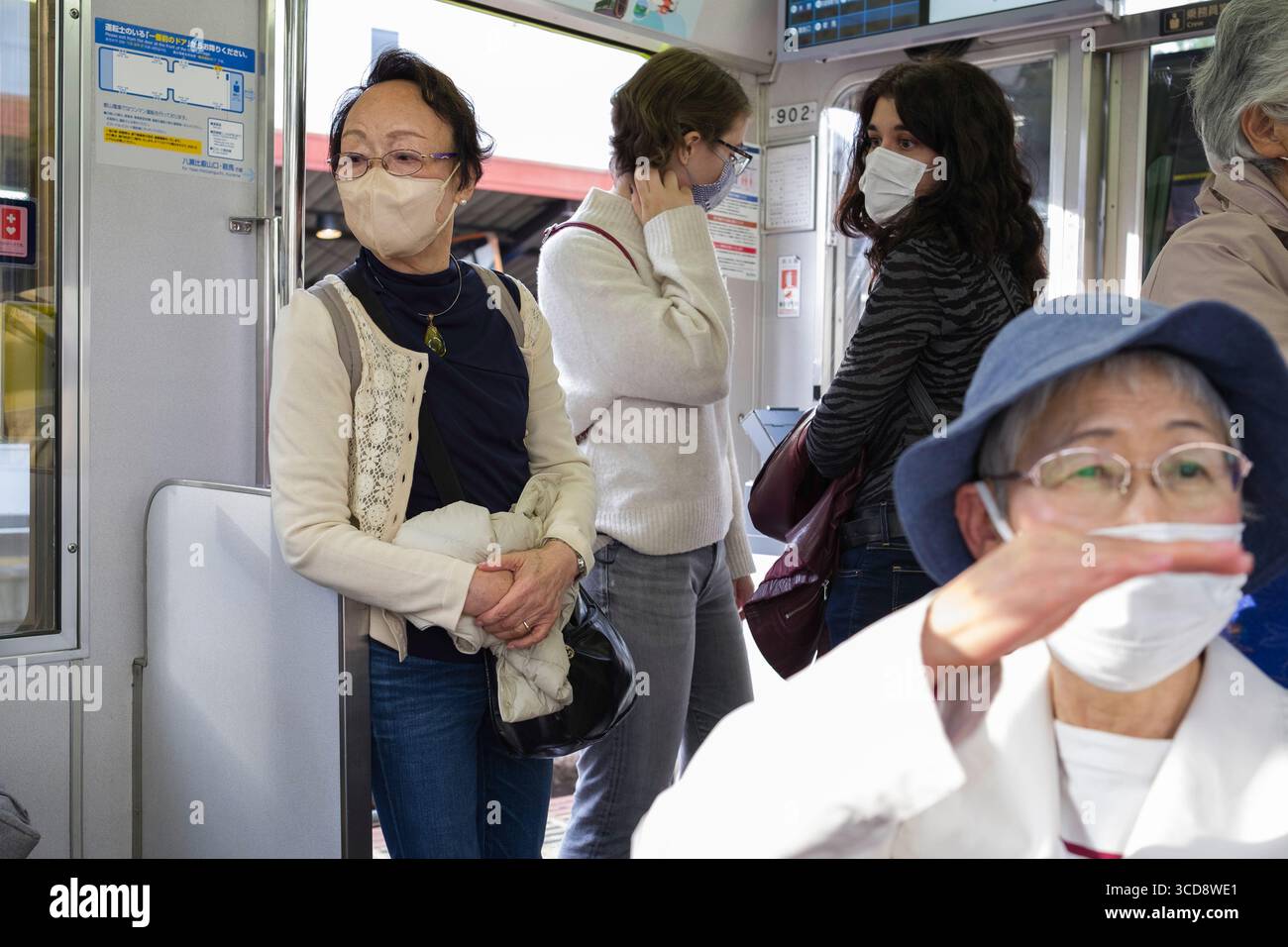 Women standing in Eiden 901 train at Demachiyanagi Station, Sakyo Ward ...
