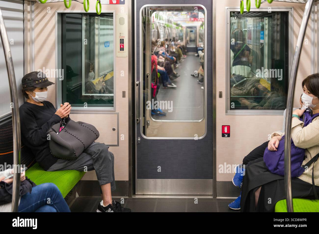 Passengers sitting in a Keihan 13000 series railcar on the Keihan Main ...