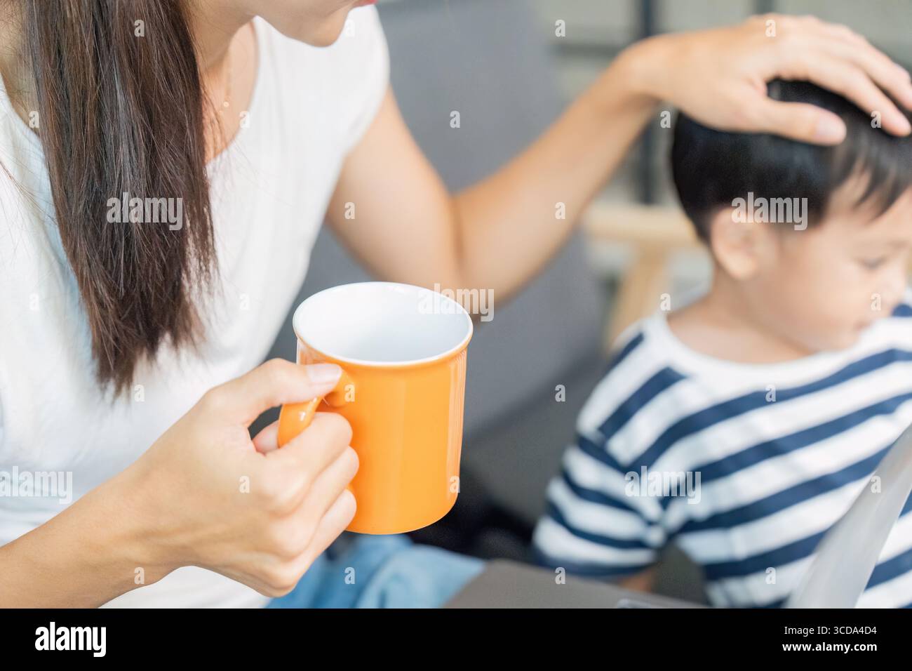 Nurturing Moments: Mother Holding Coffee While Caring for Child Stock ...