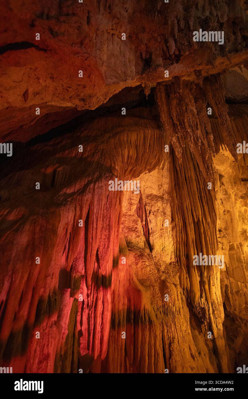 Colorful lights illuminate unique formations in a cave, showcasing ...