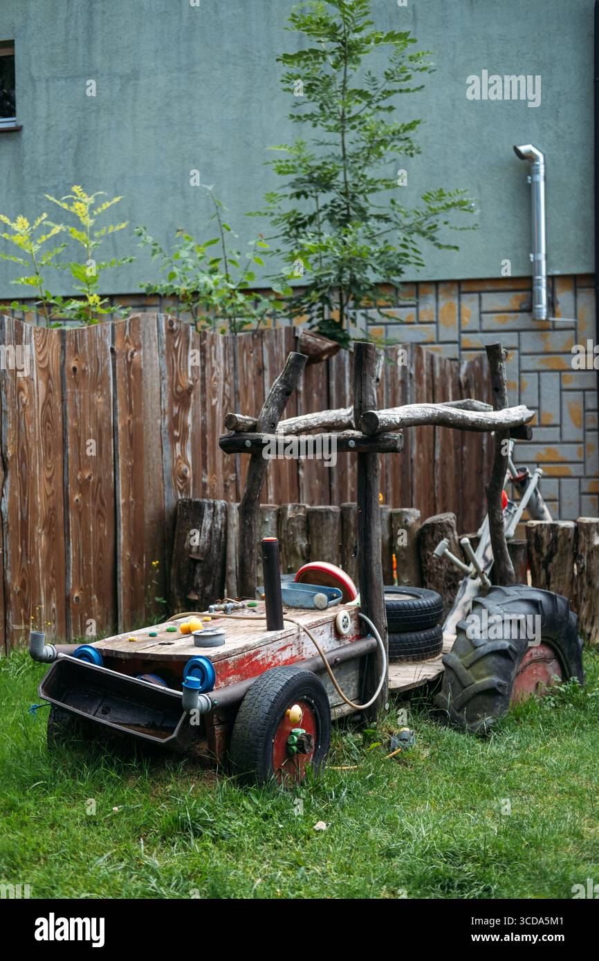 Homemade toy tractor made from wood, tires, and recycled parts in a ...