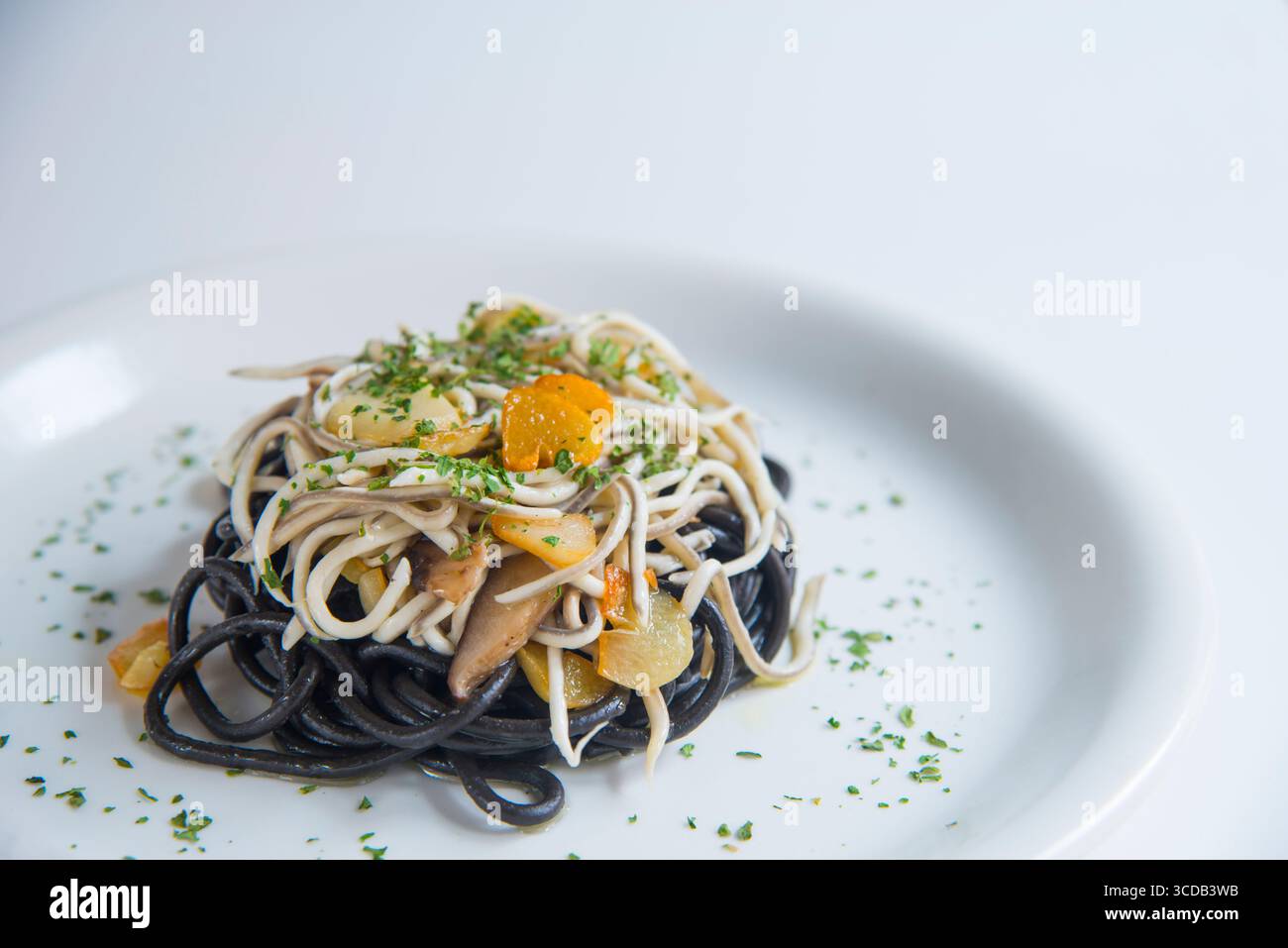 Black spaghetti with eels, garlic, mushrooms and parsley Stock Photo ...