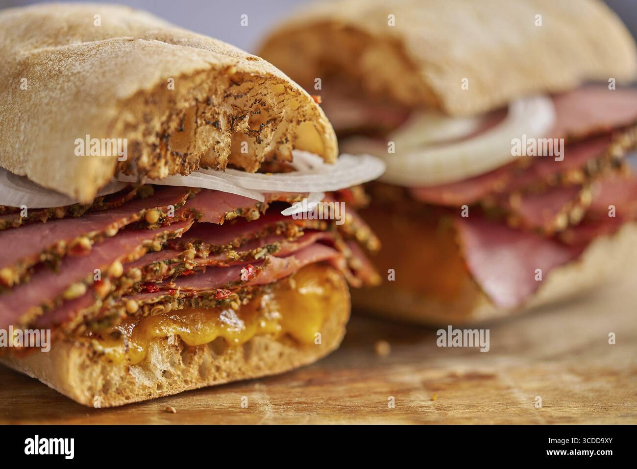 Thin cut pastrami sandwhich with delicious meet on baguette bread with ...