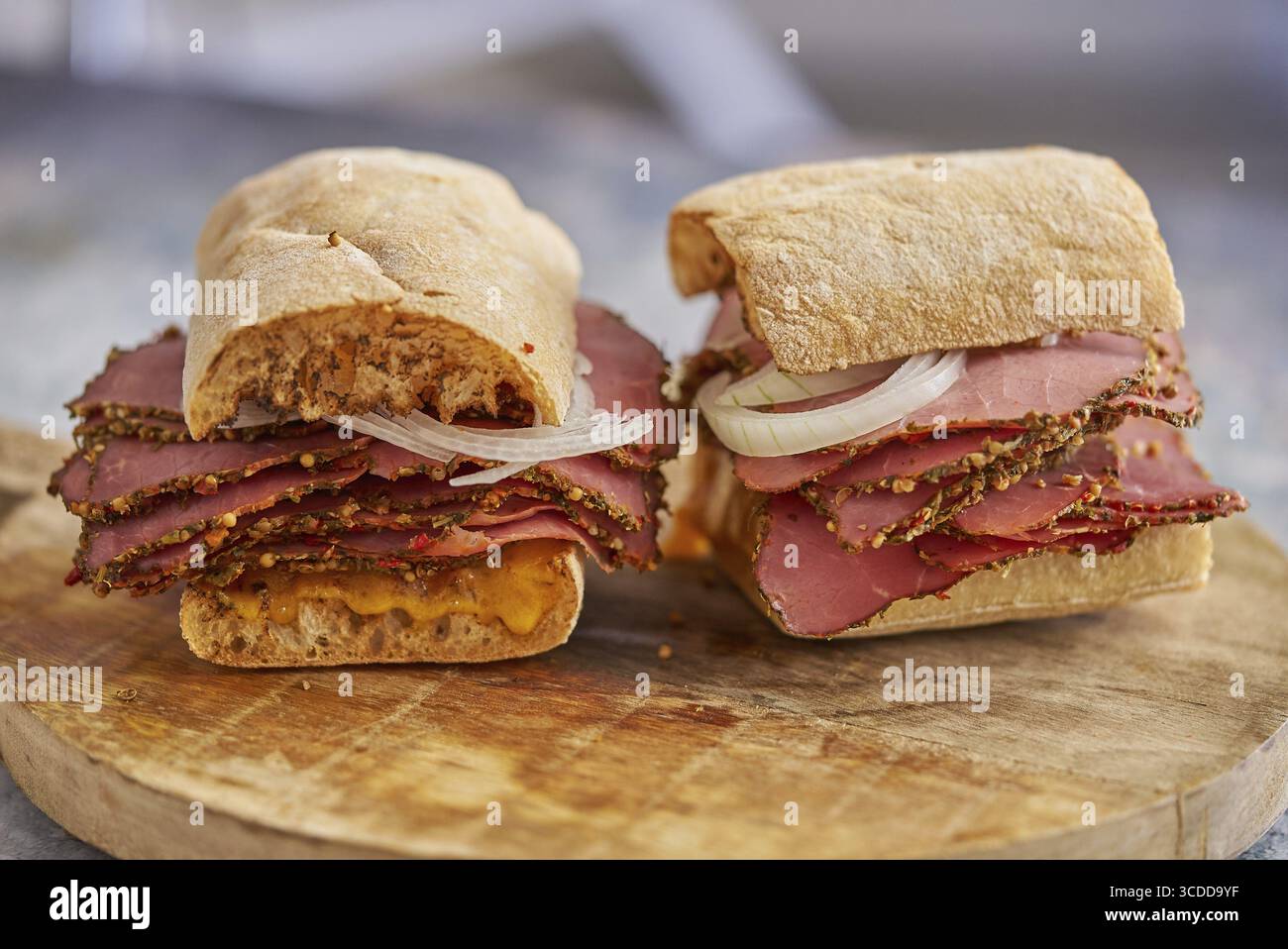 Thin cut pastrami sandwhich with delicious meet on baguette bread with ...