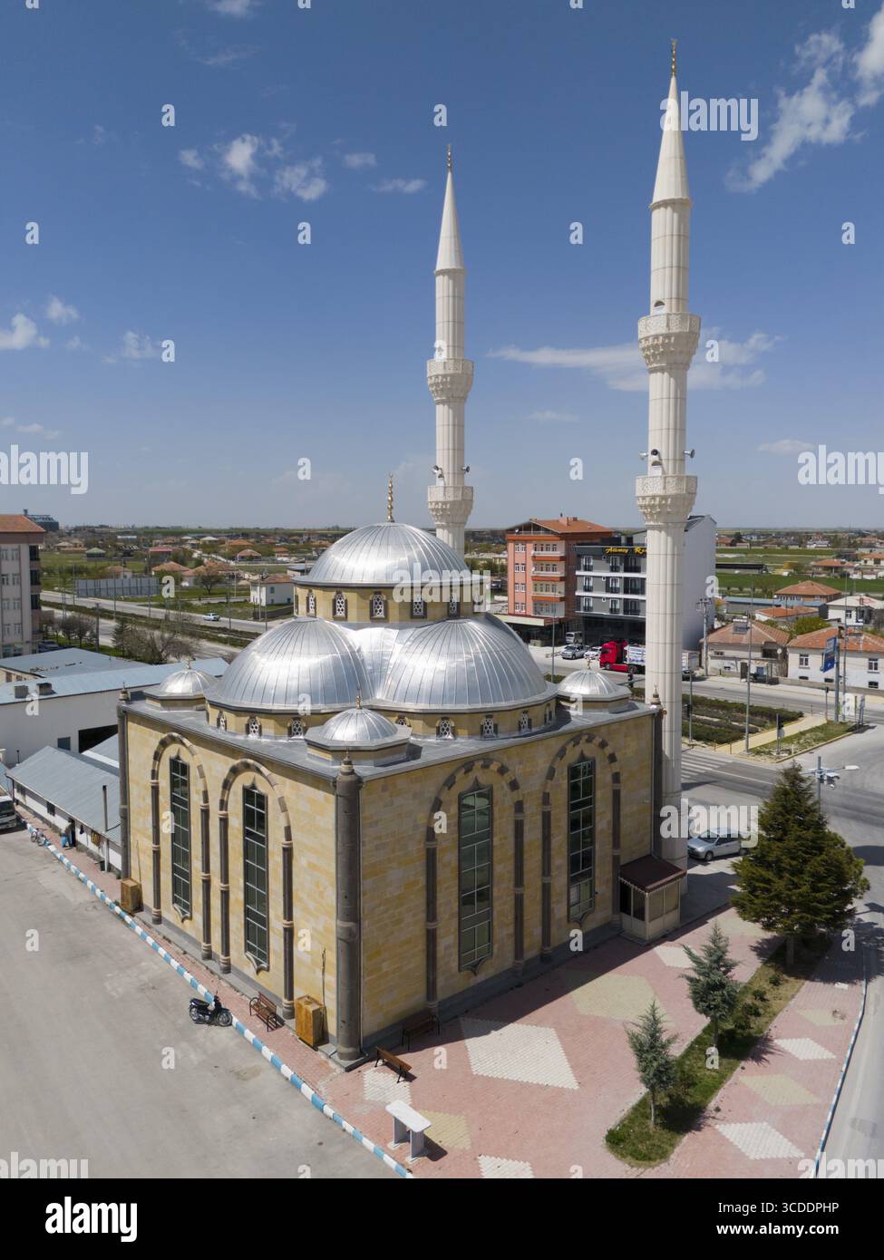 Modern mosque with two high minarets and several domes in an urban ...