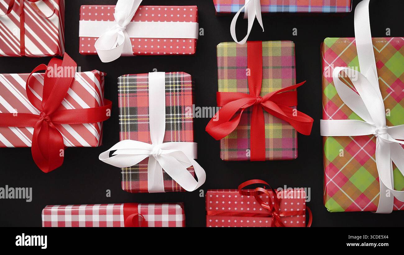 Top view of wrapped Christmas presents laid arranged on the black ...