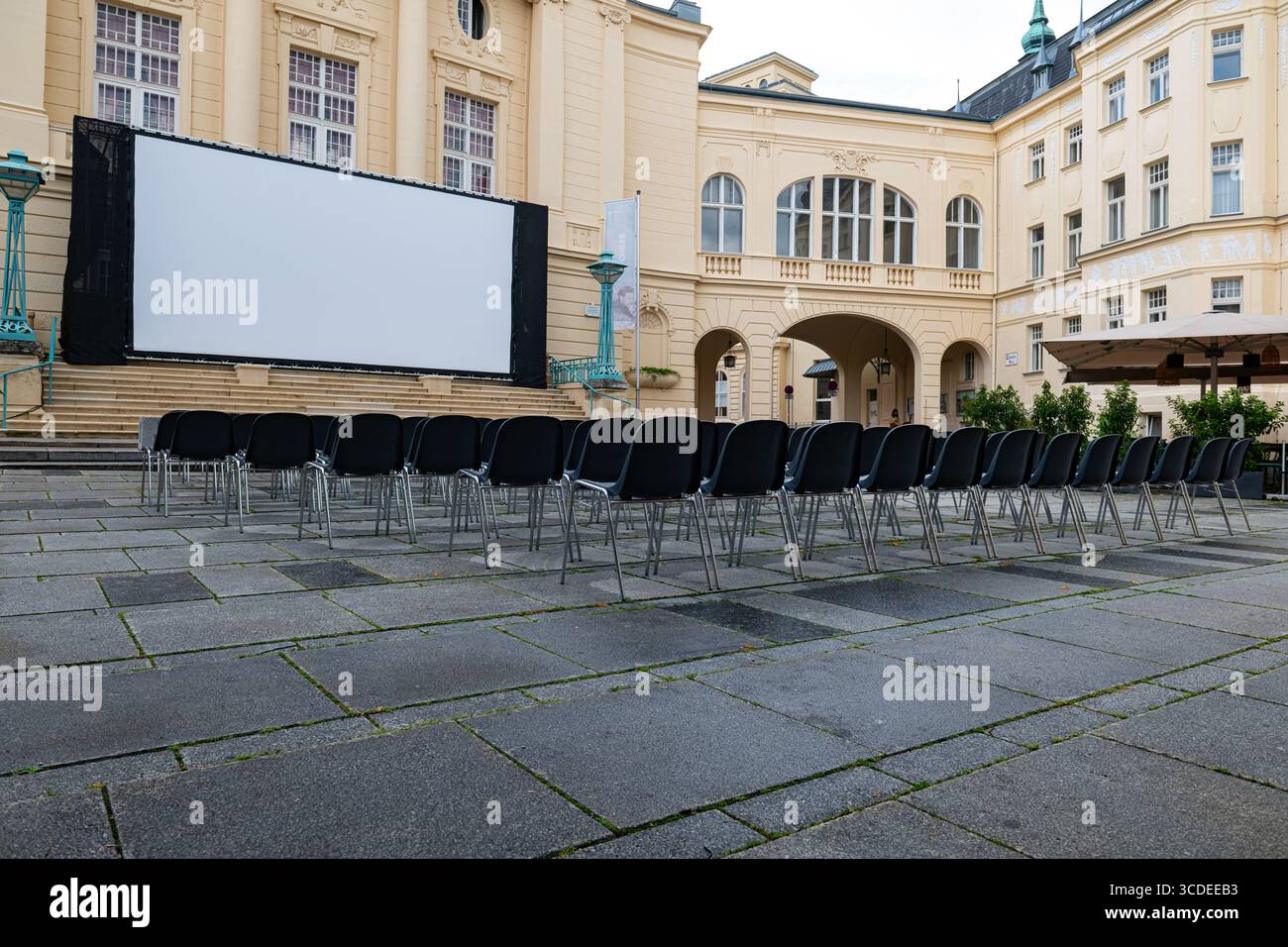 The open-air cinema set up in front of the historic building reflects ...