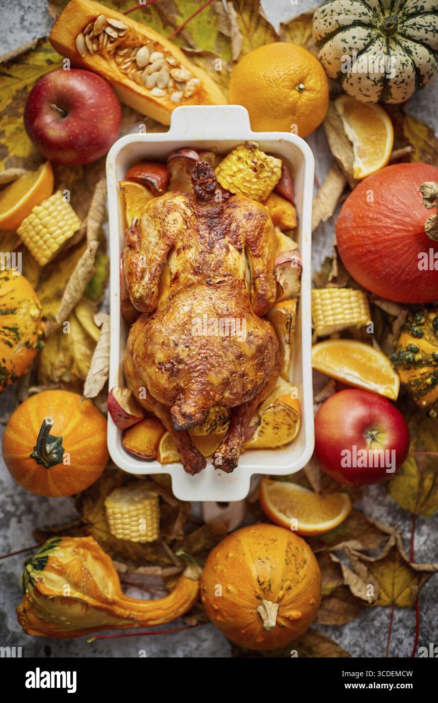 Thanksgiving dinner table with roasted whole chicken or turkey, pumpkin ...