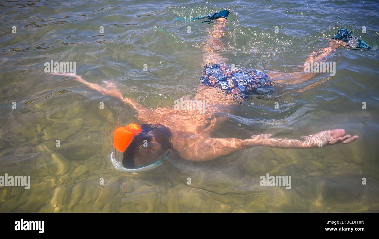 Tourist snorkeling in shallow water with full face mask and fins Stock ...